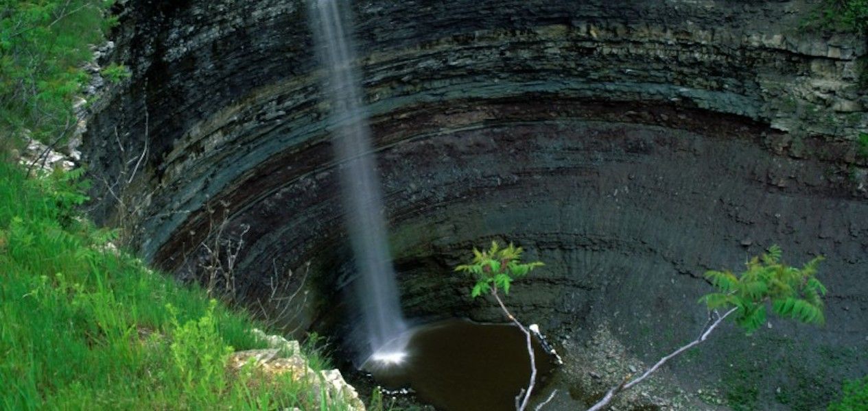 Devil's Punchbowl has a huge waterfall & is surrounded by colourful rock layers